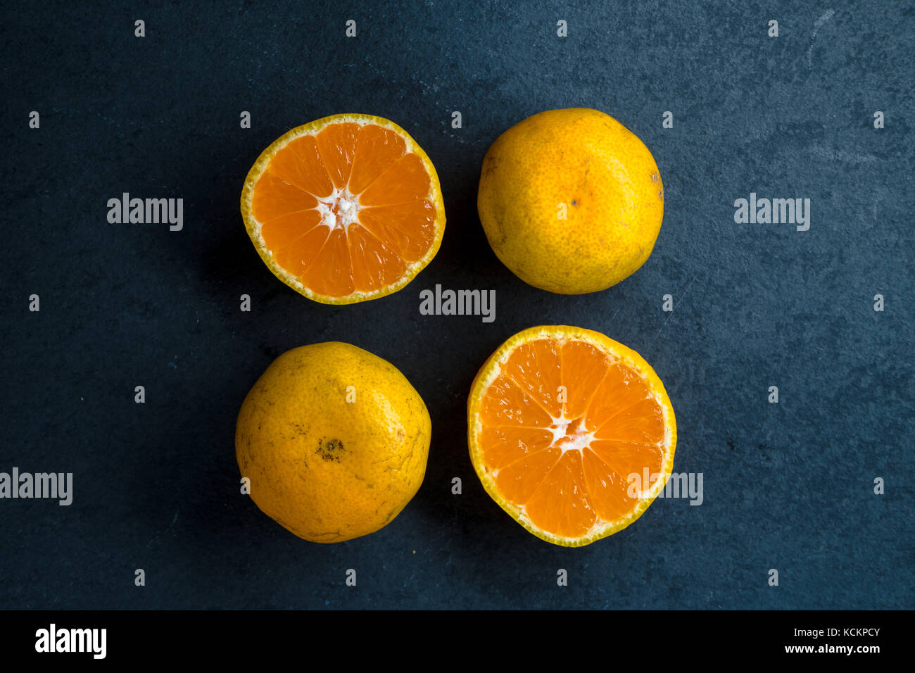 Four halves of an orange on a blue stone horizontal Stock Photo - Alamy