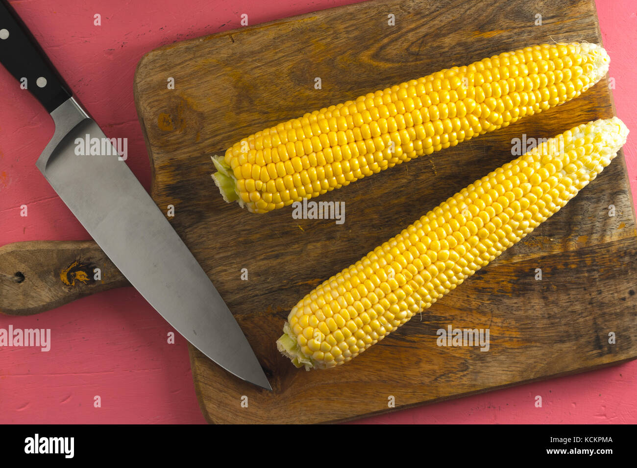 Fresh whole corn on a cutting board and kitchen knife horizontal Stock ...