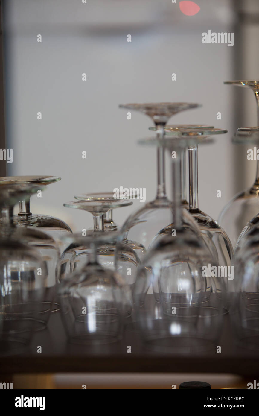 Inverted wineglasses await at the bar Stock Photo - Alamy