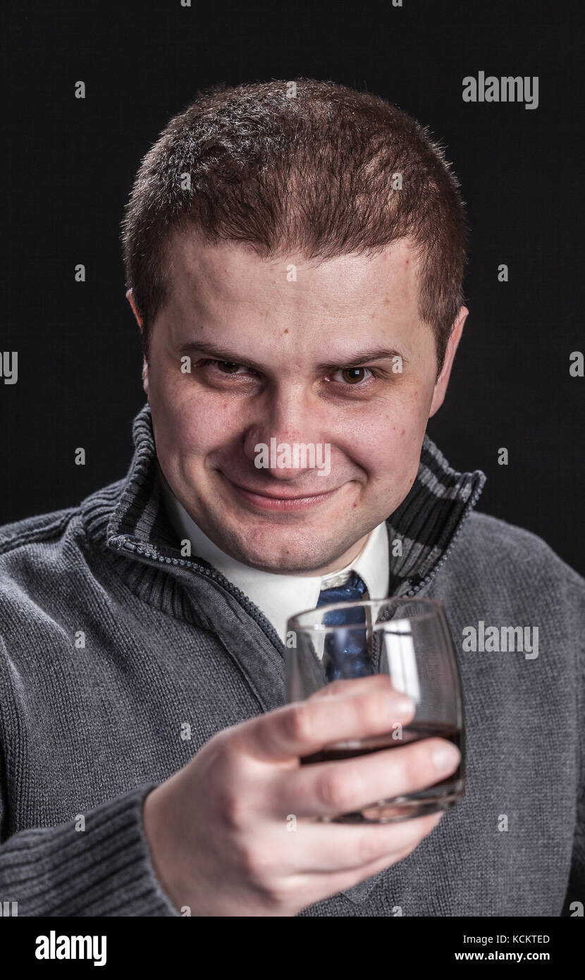 man with a drinking glass in his hand, dark background Stock Photo - Alamy