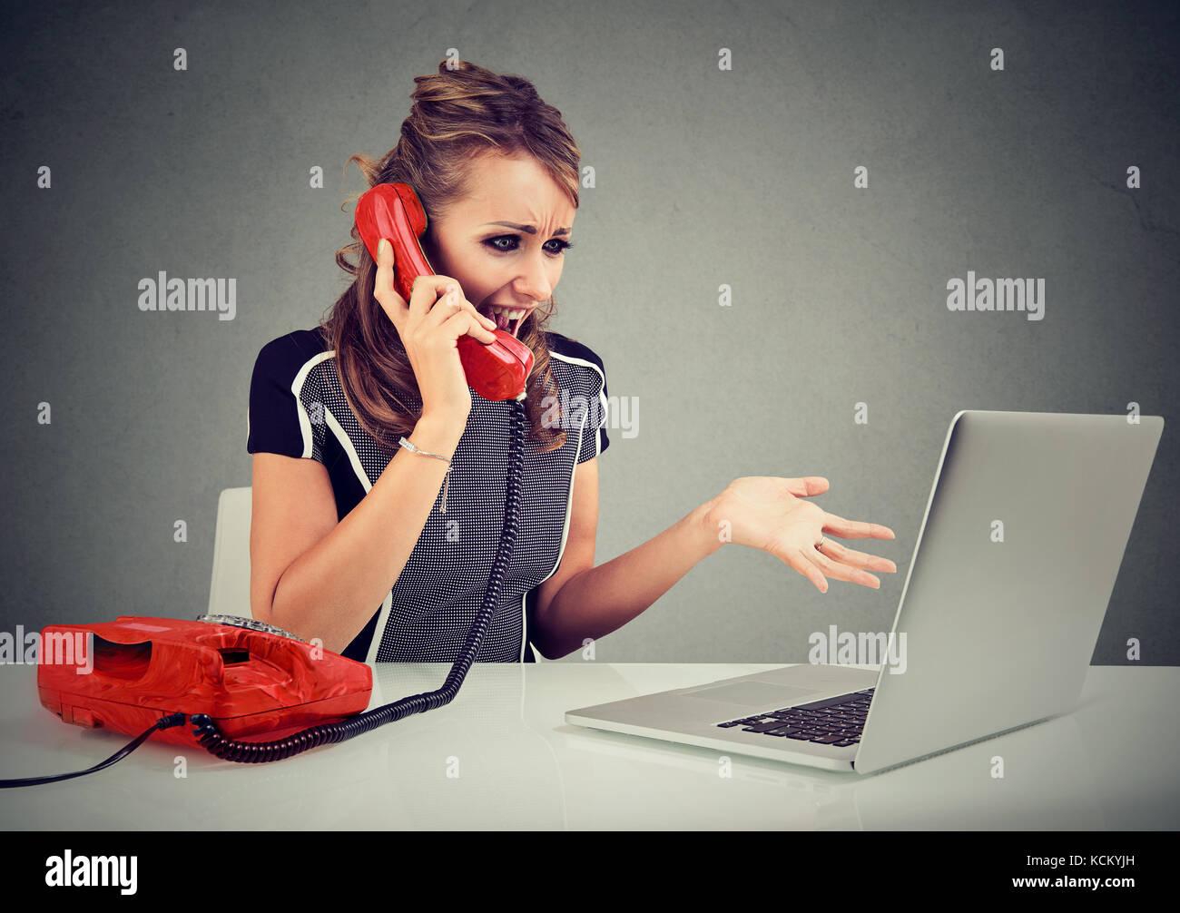 Angry woman calling customer service with a laptop failure Stock Photo ...