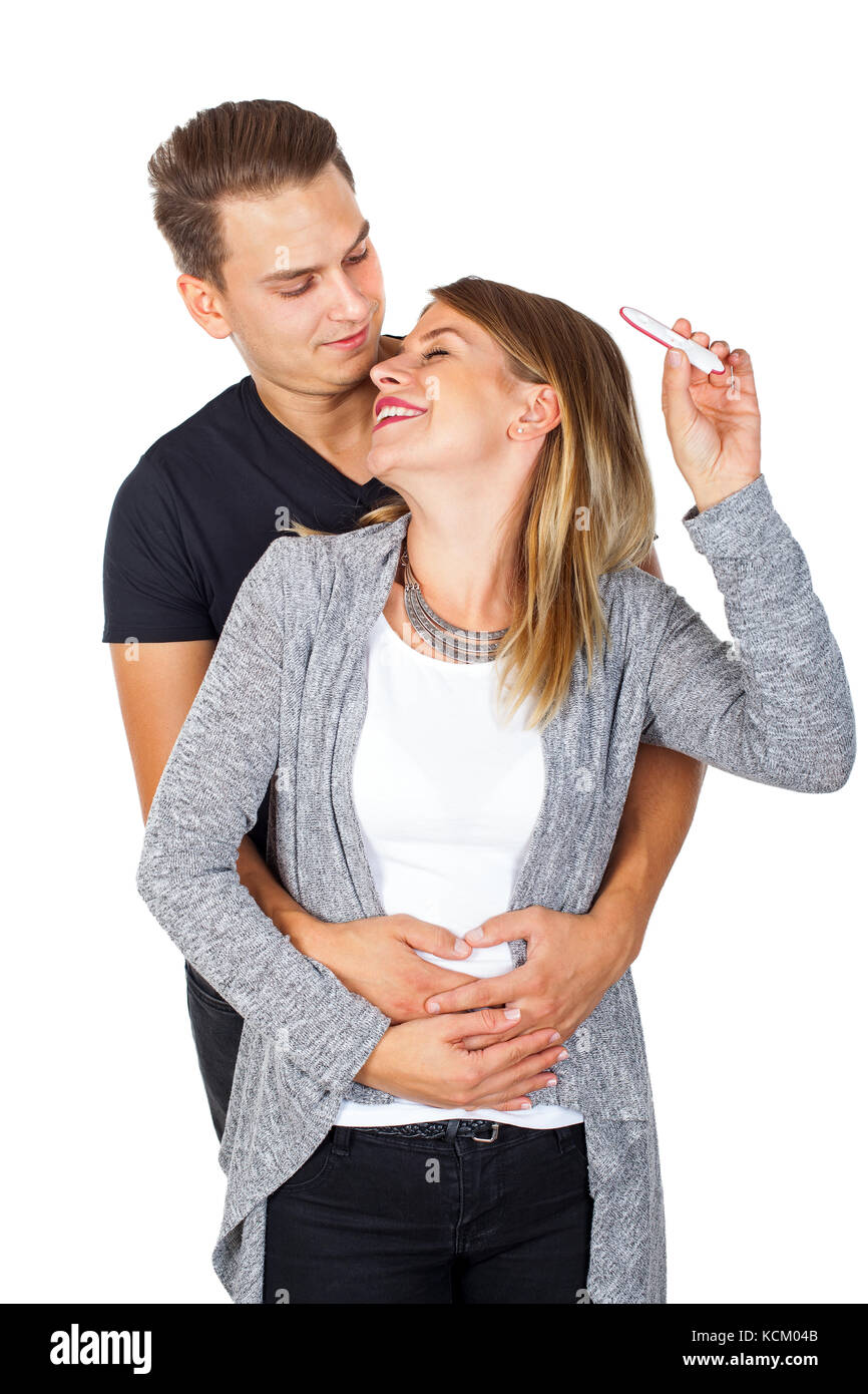 Pregnancy test positive, happy couple embracing on isolated background ...