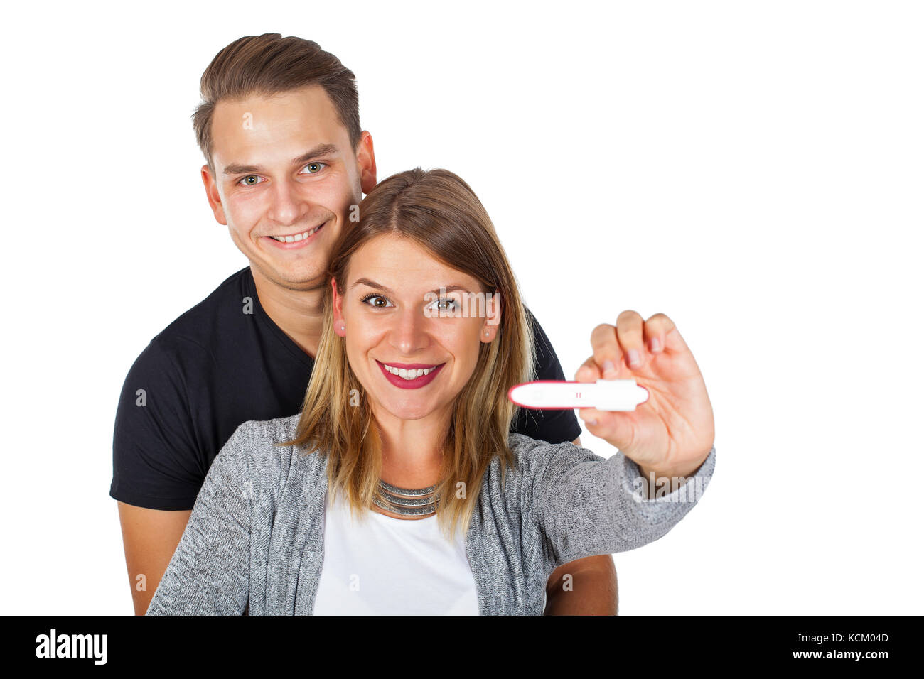 Pregnancy test positive, happy couple embracing on isolated background ...