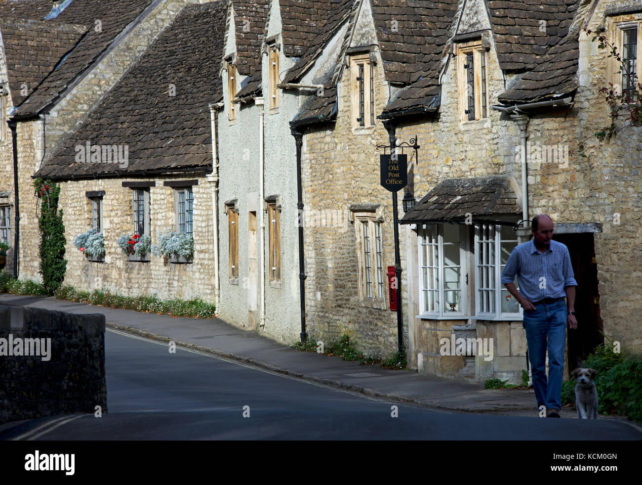 Man walking dog, Castle Combe, Wiltshire, England UK Stock Photo - Alamy