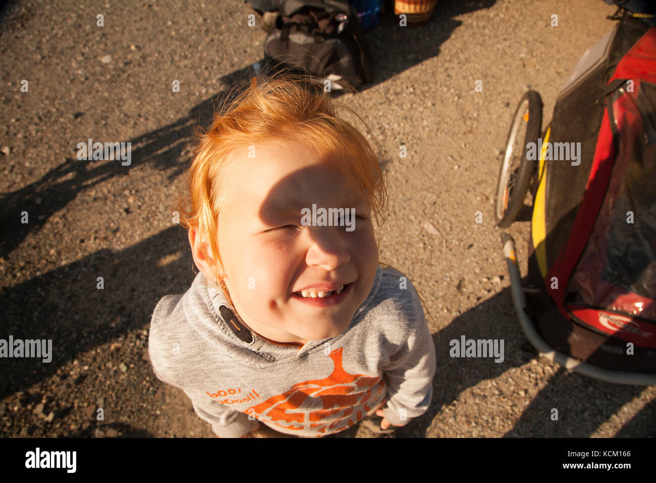 Smiling happy ginger haired girl looking strait into the camera with ...