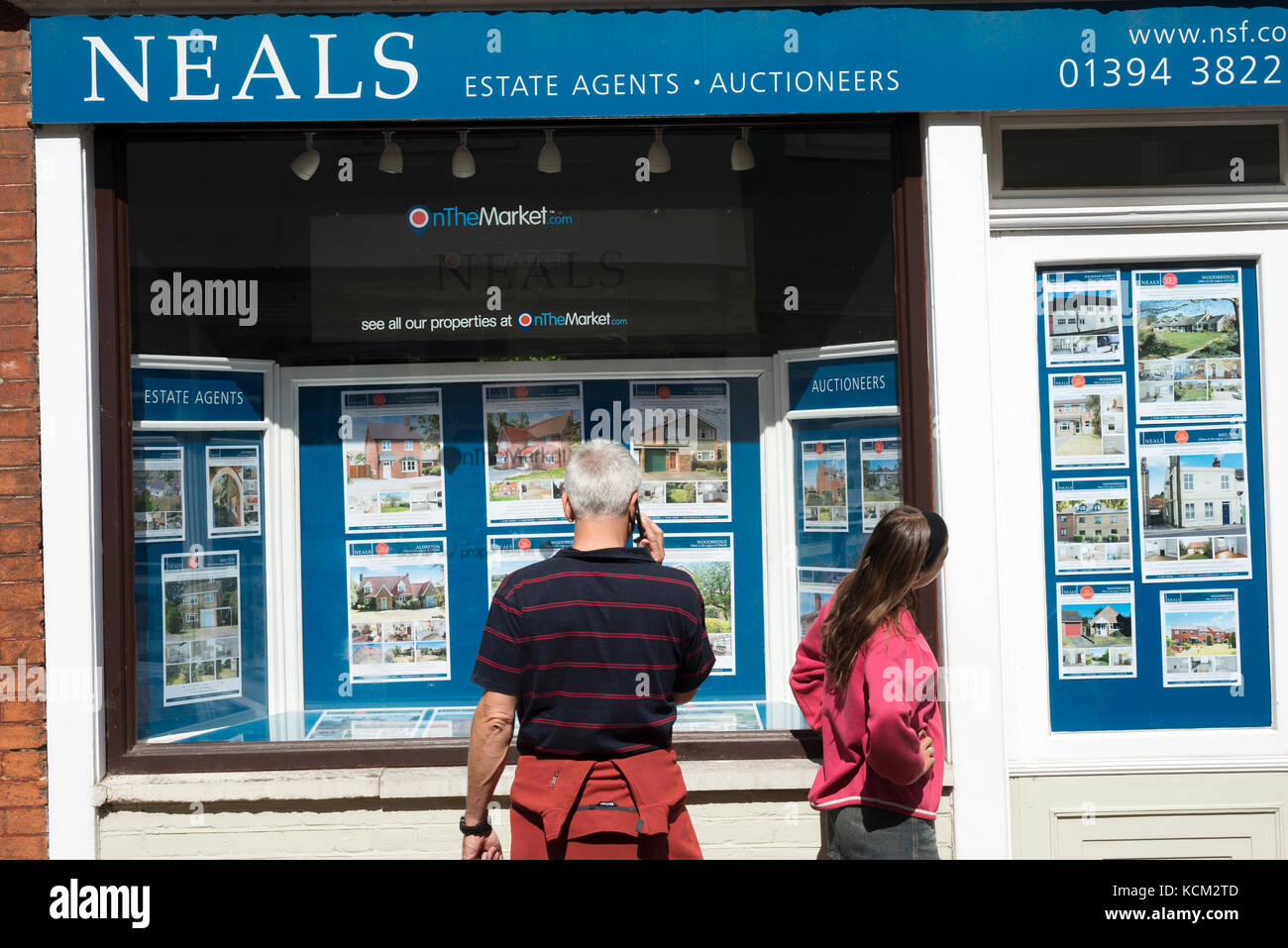 Couple looking in estate agents window Stock Photo - Alamy