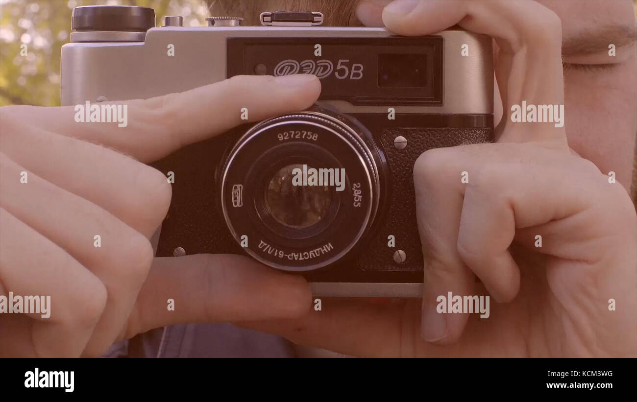 Male hand rotate the camera lens. the photographer sets up the camera ...