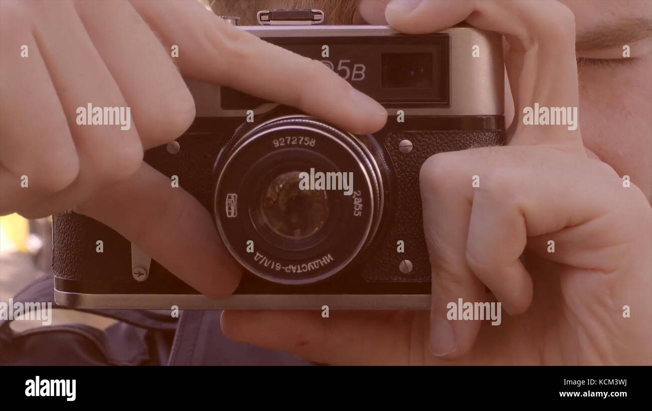 Male hand rotate the camera lens. the photographer sets up the camera ...