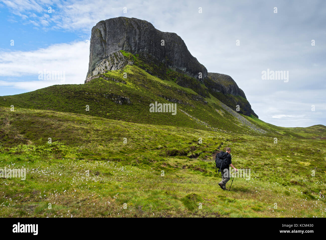 A walker below the nose of An Sgùrr, or the Sgurr of Eigg, on the Isle ...