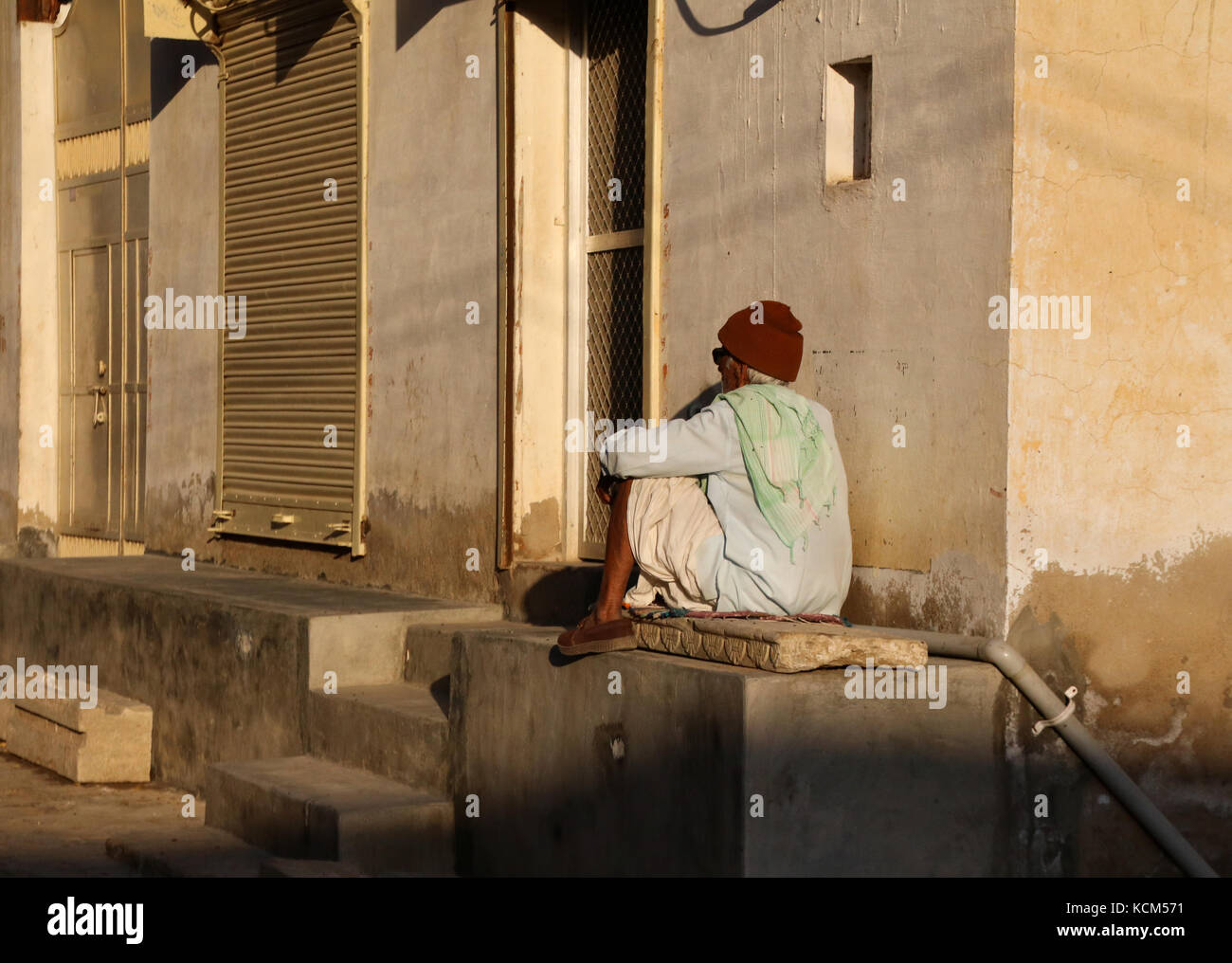 Man sitting on doorstep with back to camera Stock Photo - Alamy