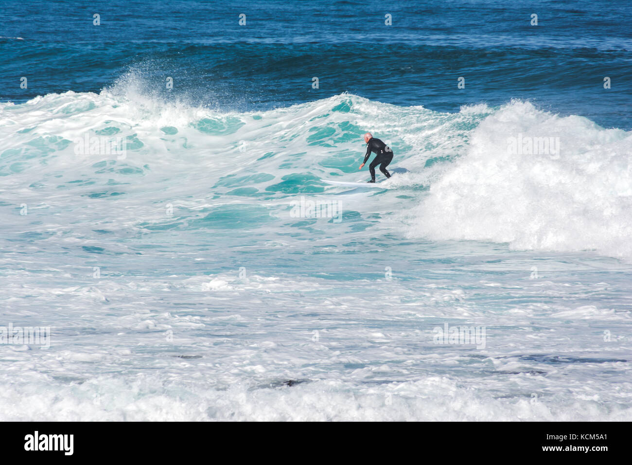 Man surfing with wave crashing behind him Stock Photo - Alamy