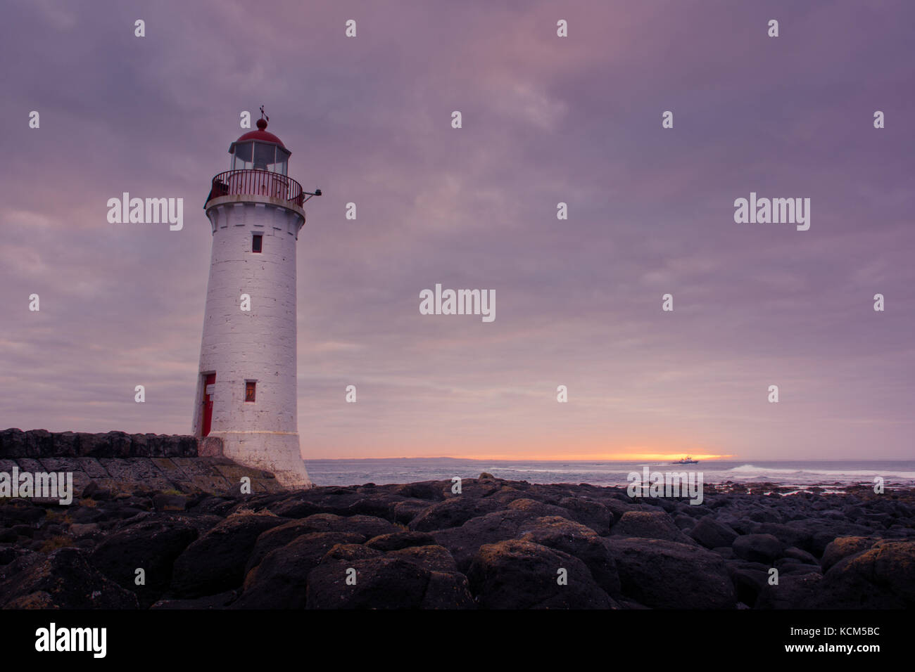 Port Fairy lighthouse at sunrise with rocks Stock Photo - Alamy