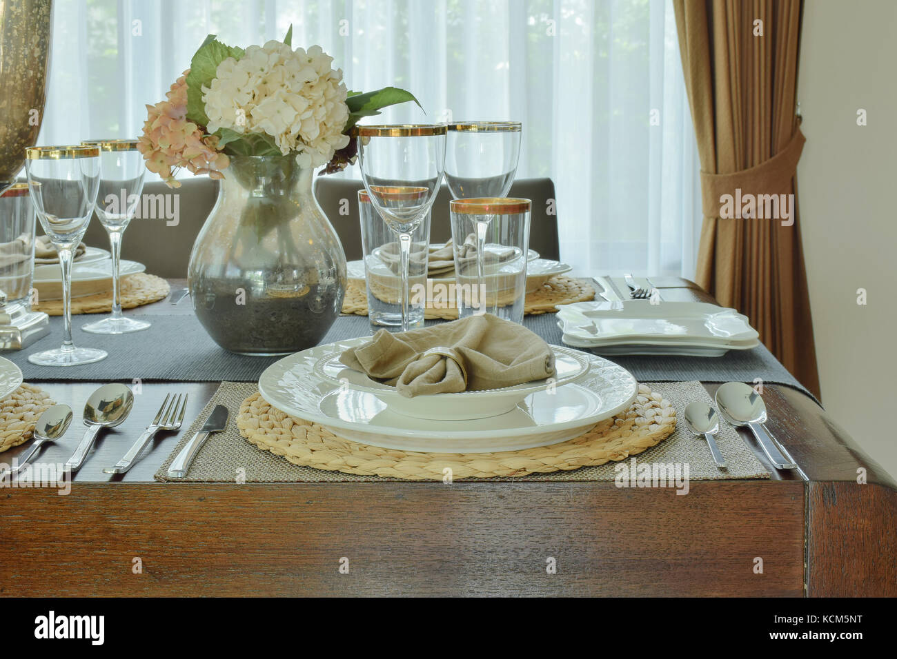 Plates and napkin setting on dining table Stock Photo - Alamy
