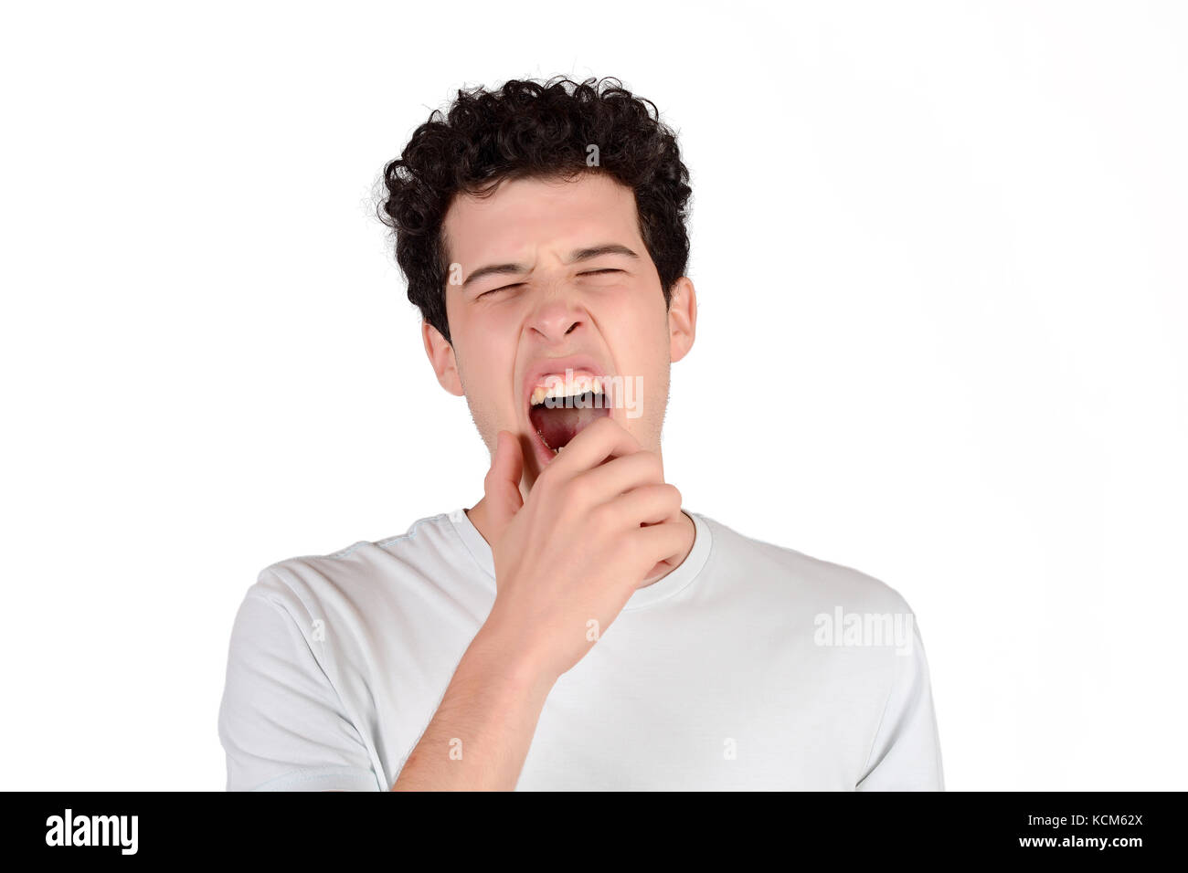Portrait of a young man yawning. Isolated white background Stock Photo ...