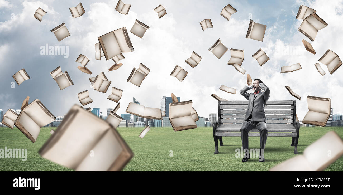 Many old books falling from above and student guy sitting on ben Stock ...