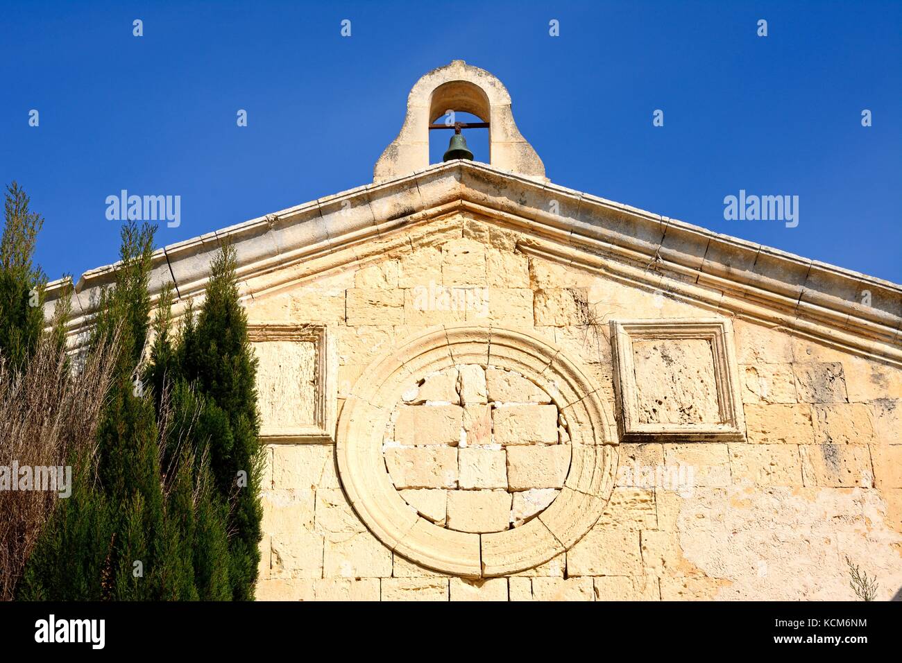Small bell tower on top of an old church with a bricked in round window ...