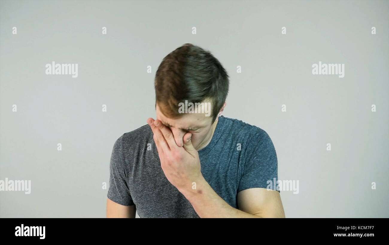 Young man sneezing on a white background, slow motion Stock Photo - Alamy