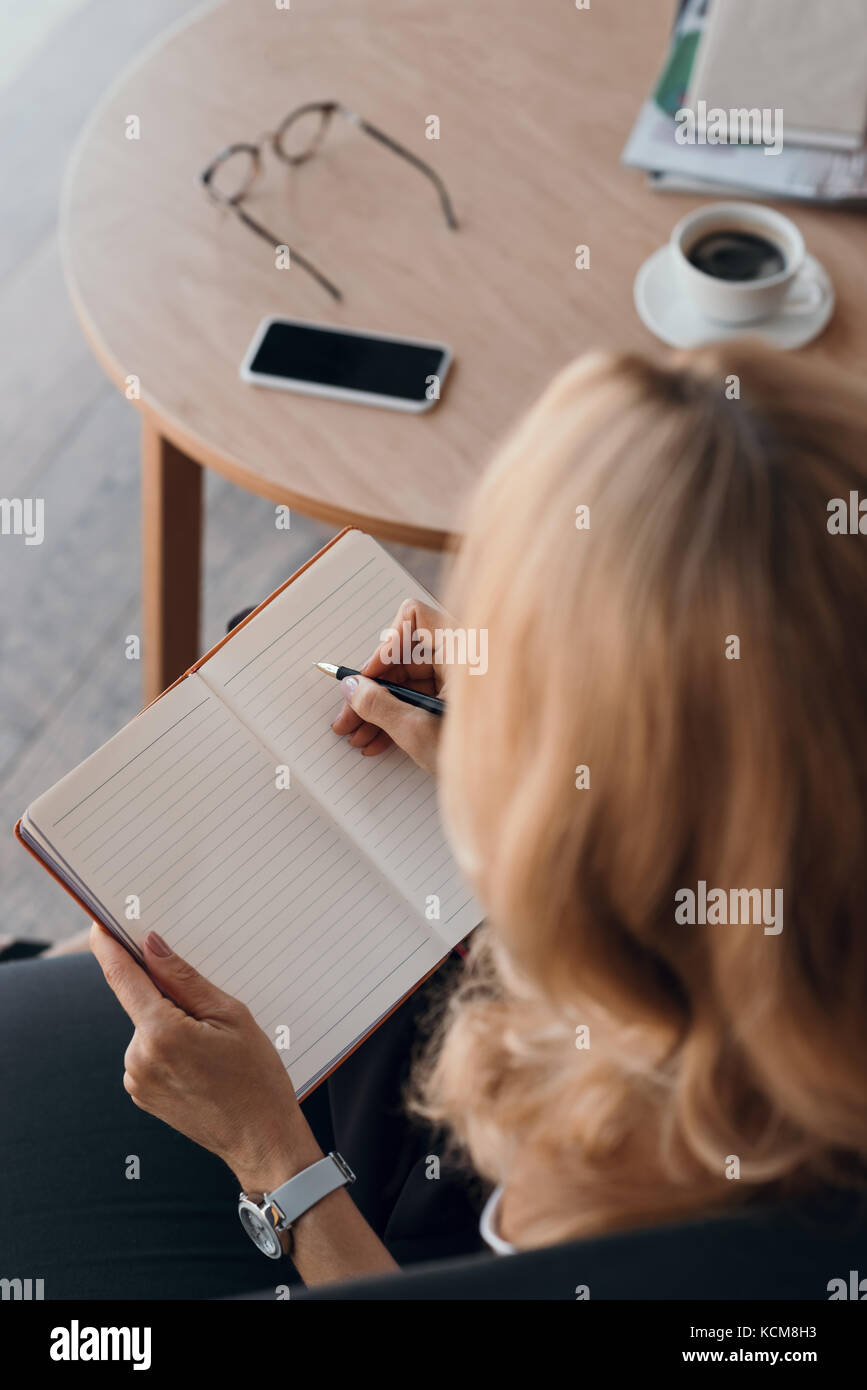 woman writing in notebook Stock Photo - Alamy