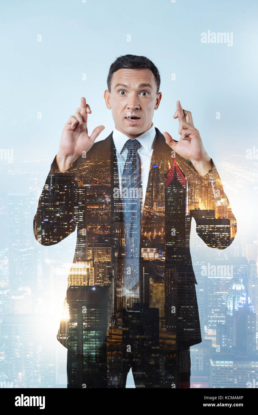 Anxious manager keeping fingers crossed Stock Photo - Alamy