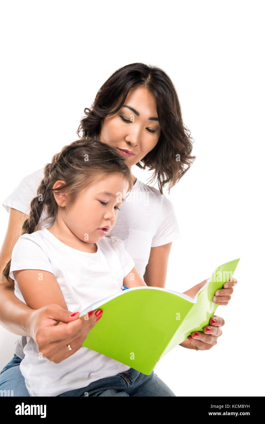 mother and daughter writing in copybook Stock Photo - Alamy