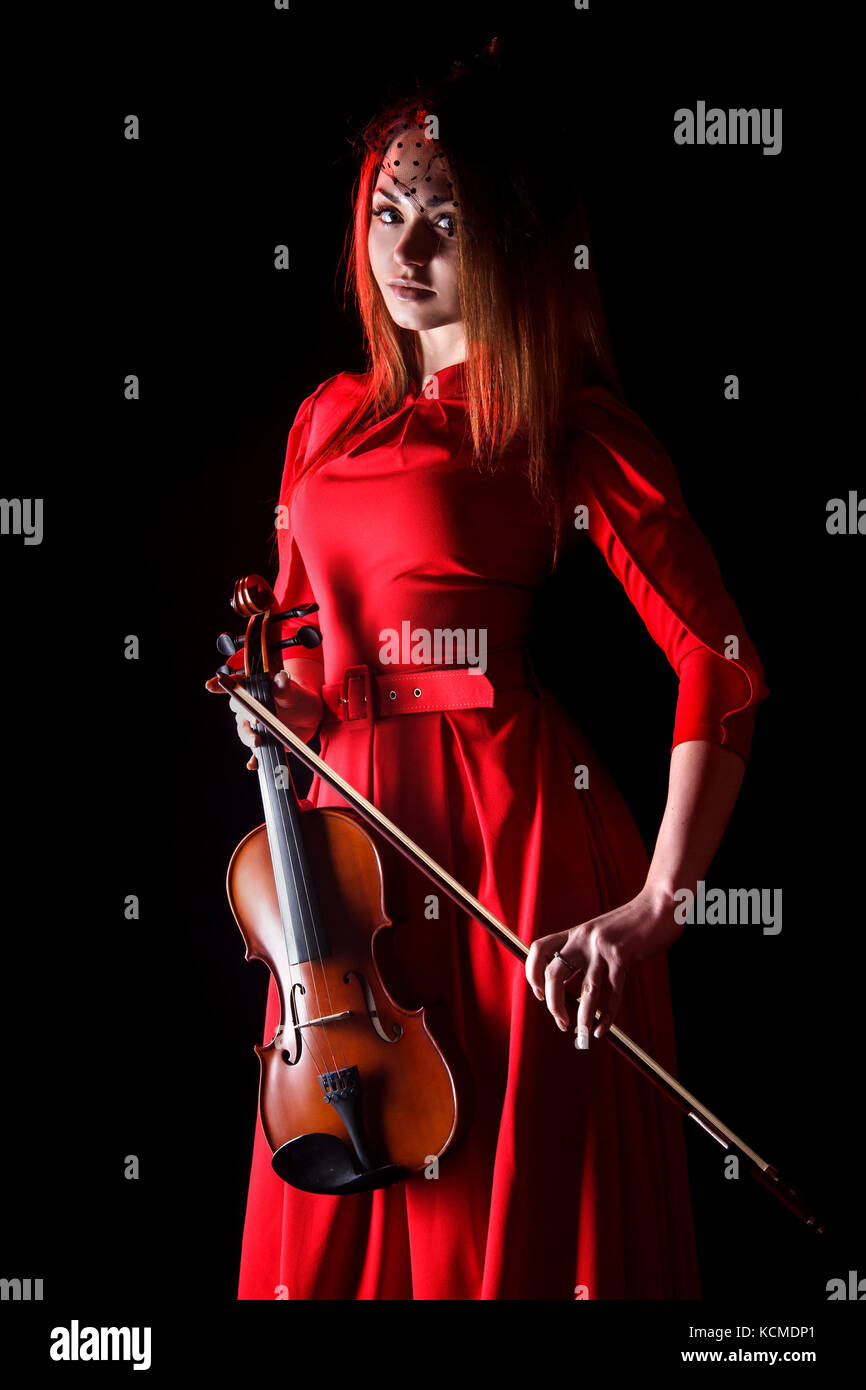 Pretty young woman holding a violin over black background Stock Photo ...