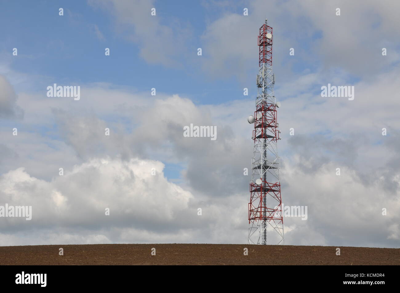 Telecommunication tower against cloudy blue sky Stock Photo - Alamy