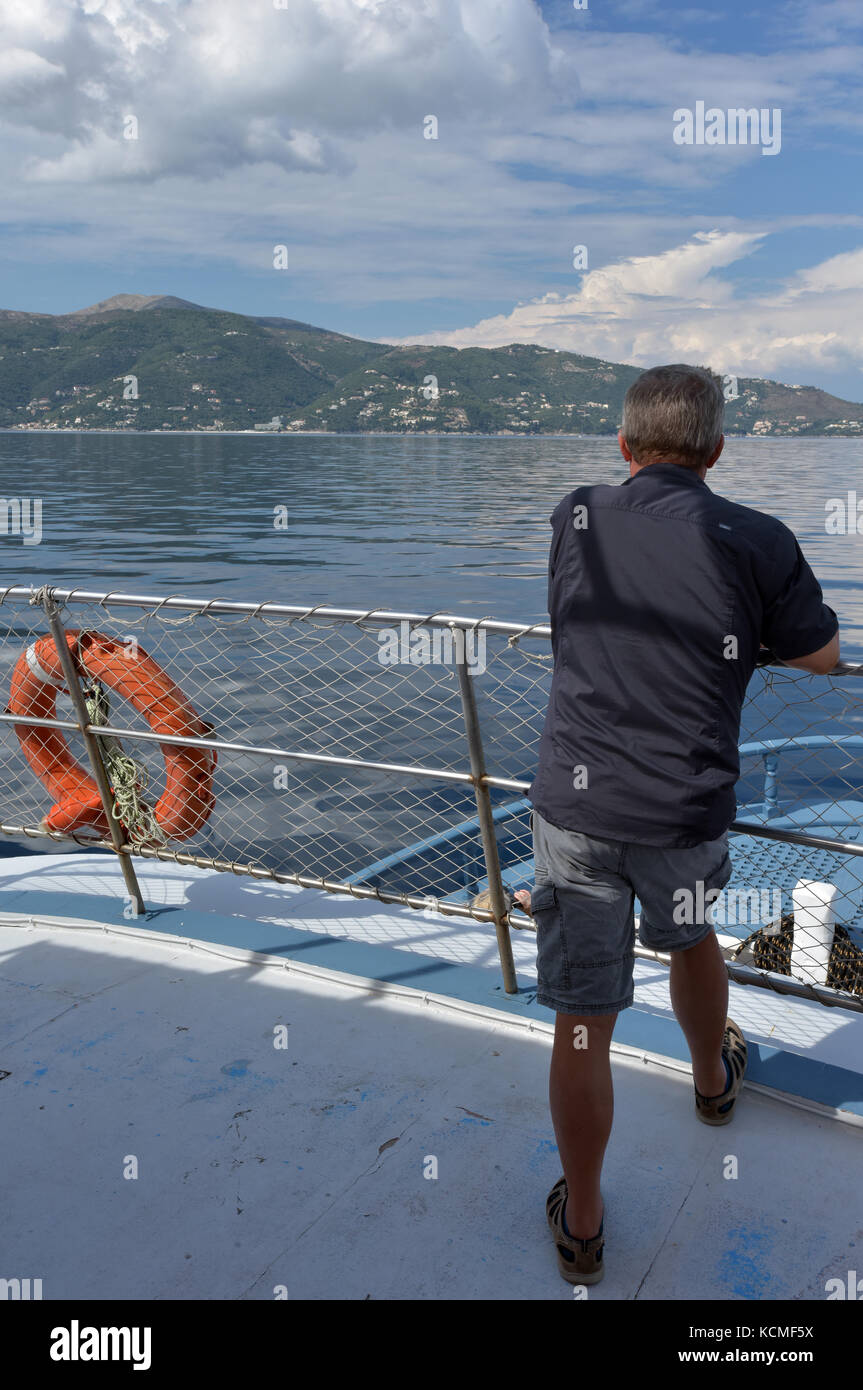 a man standing at the railings of a ship, boat or ferry looking at the ...