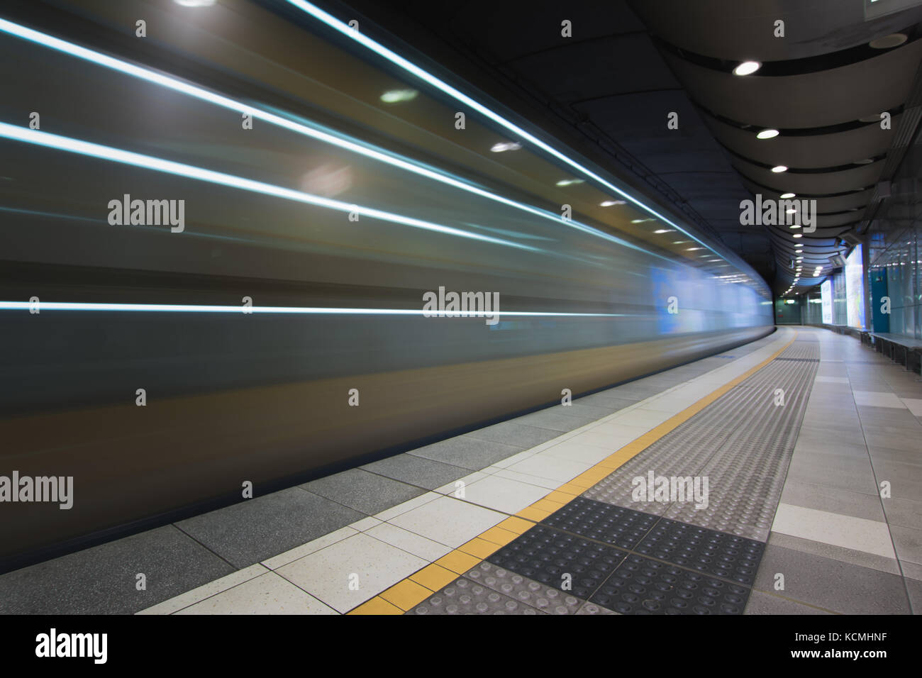 passenger train speeding through an underground station of a urban city ...
