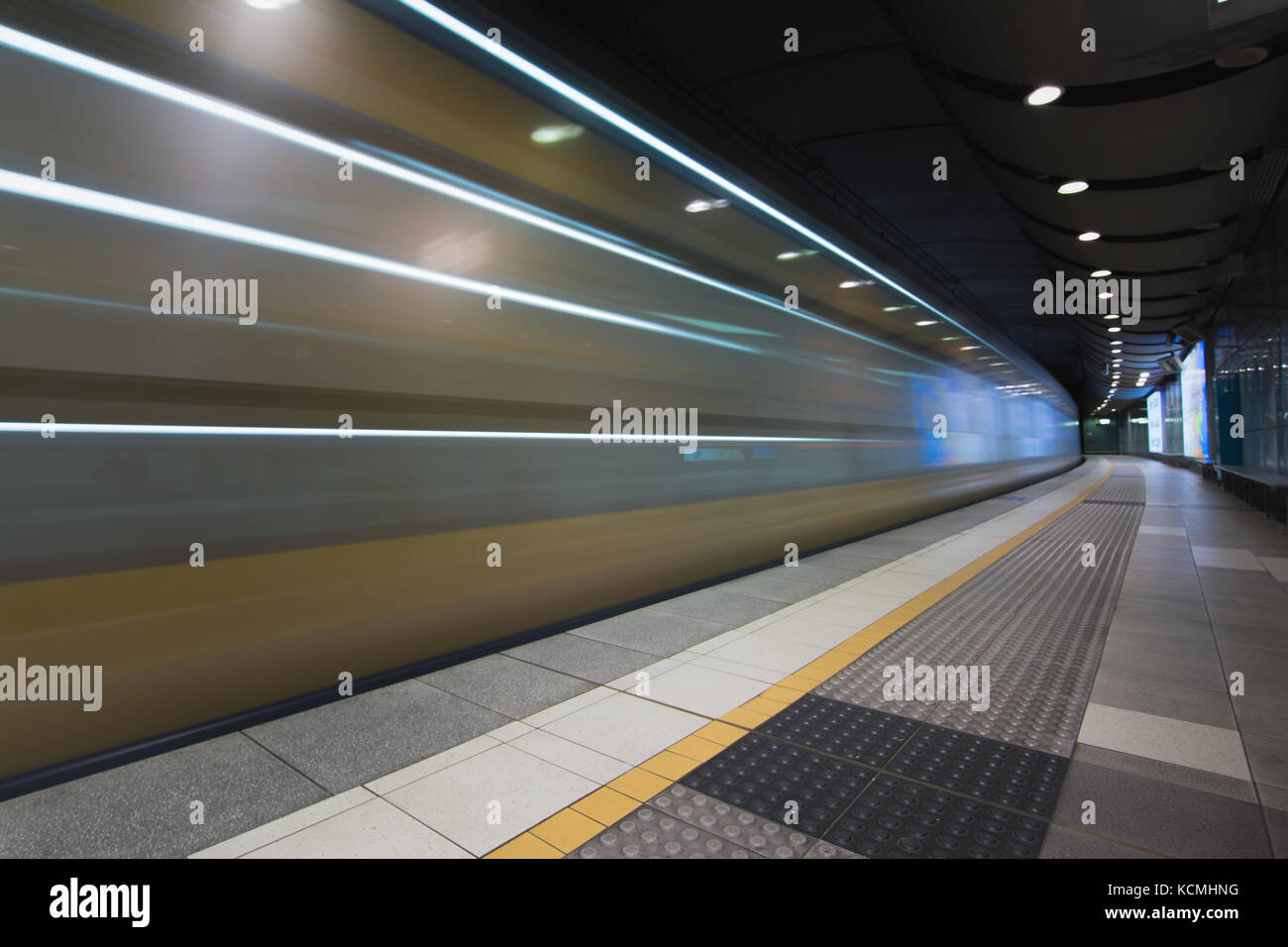 passenger train speeding through an underground station of a urban city ...