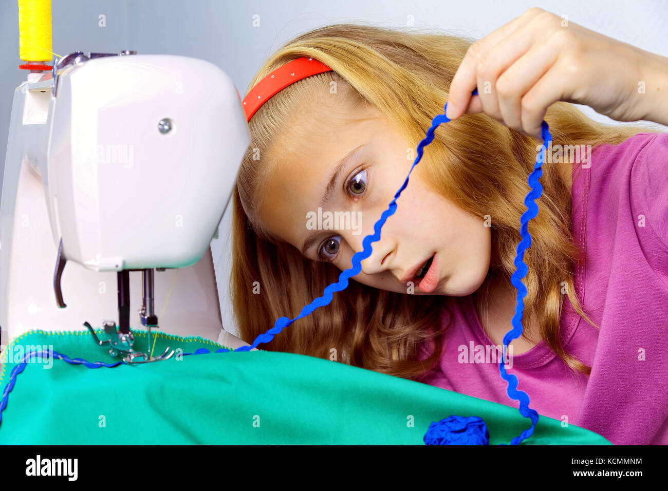 Teen girl frightened by her mistake when sewing on a sewing machine ...