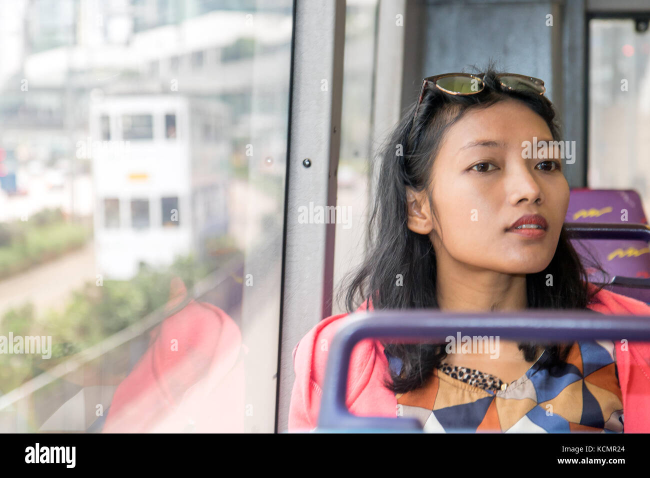 Young woman travels with a double-decker bus in the city center. The ...