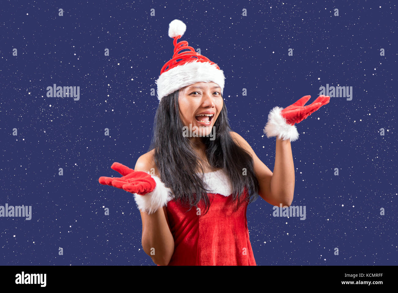 Cheerful Mrs. Claus looks to the camera with her hands shows stars ...