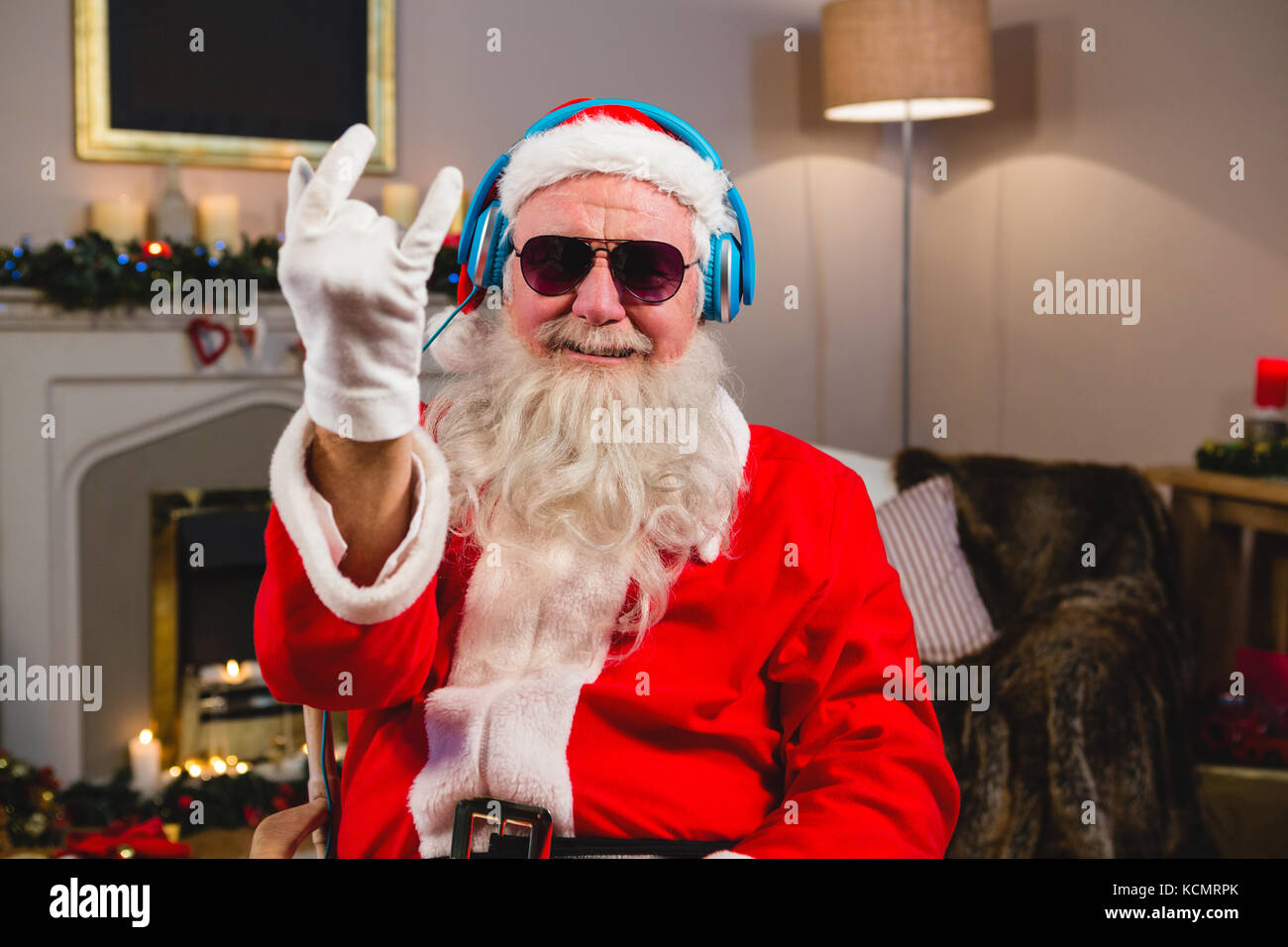Smiling santa claus listening to music on headphones at home Stock ...
