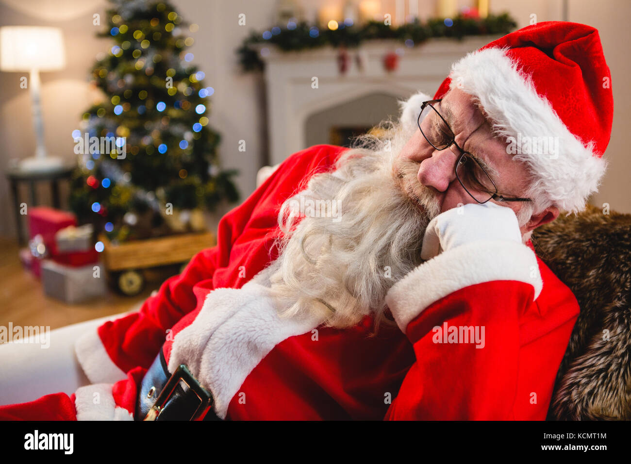 Santa claus relaxing on sofa in living room at home during christmas ...