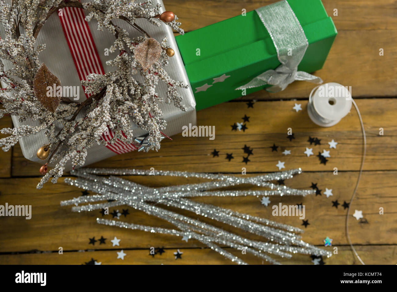 High angle view of gift boxes with wreath and thread spool by sticks on ...