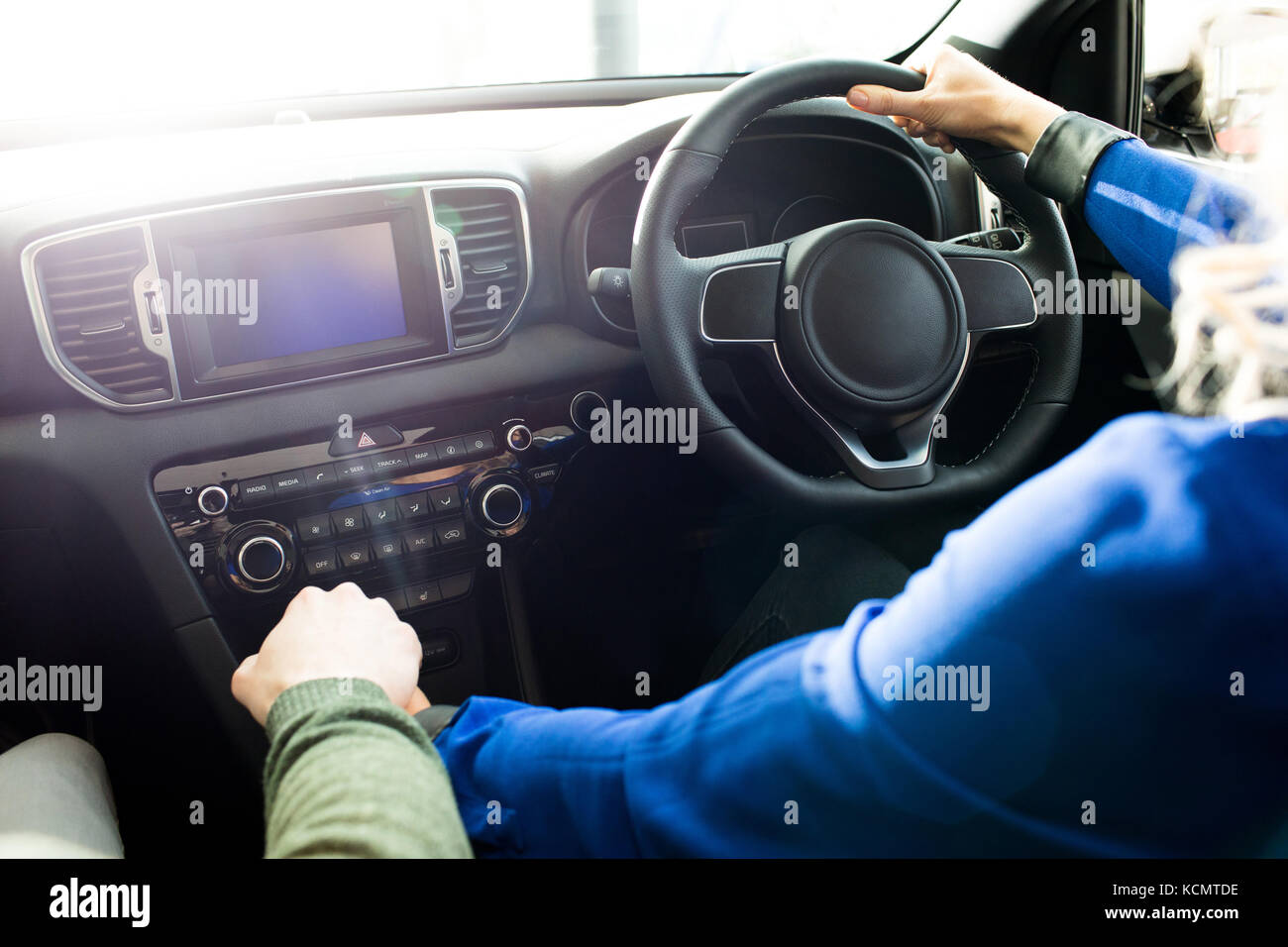 Cropped image of couple test driving car at showroom Stock Photo - Alamy