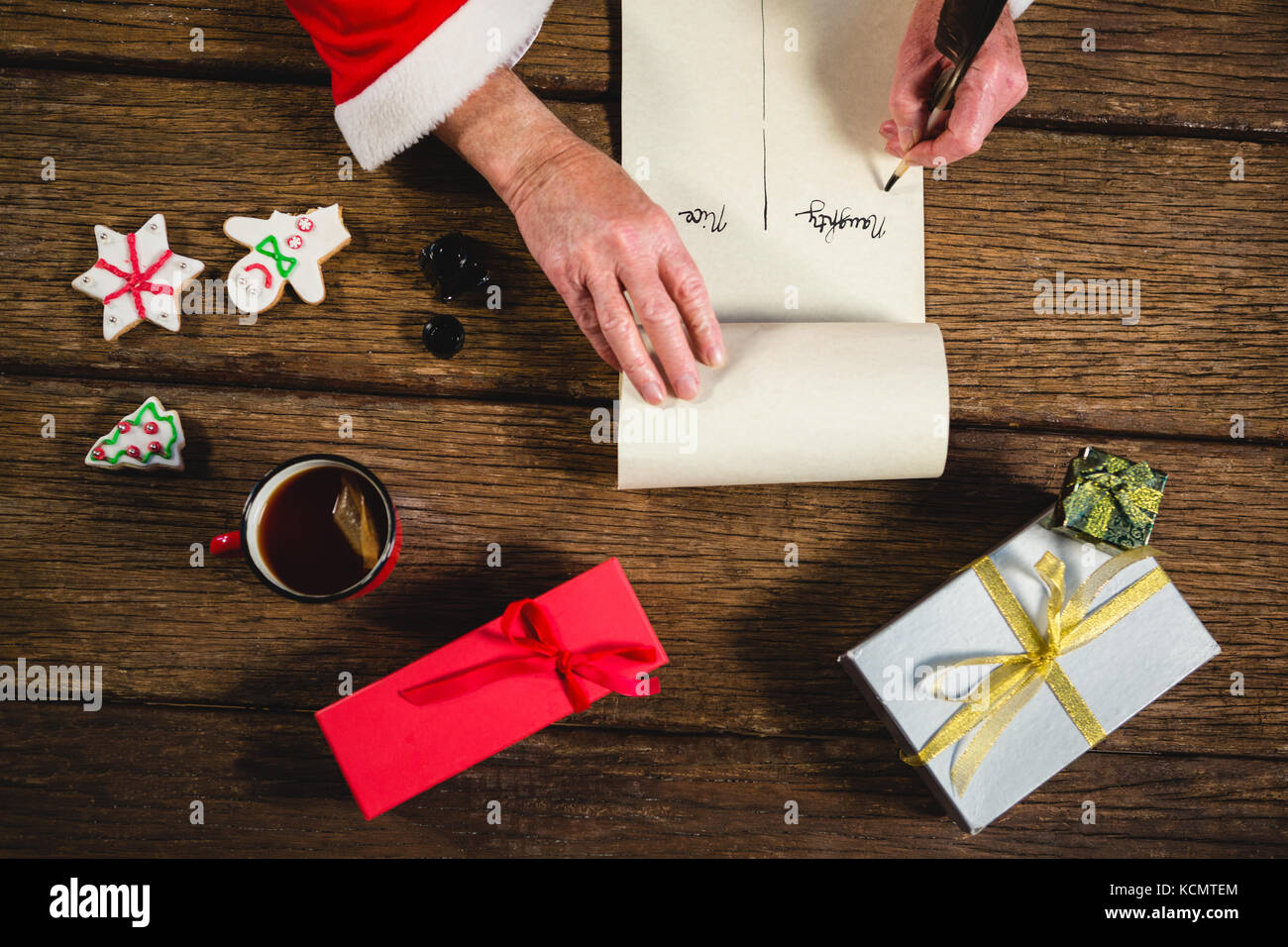 Hands of Santa Claus writing on scroll Stock Photo - Alamy