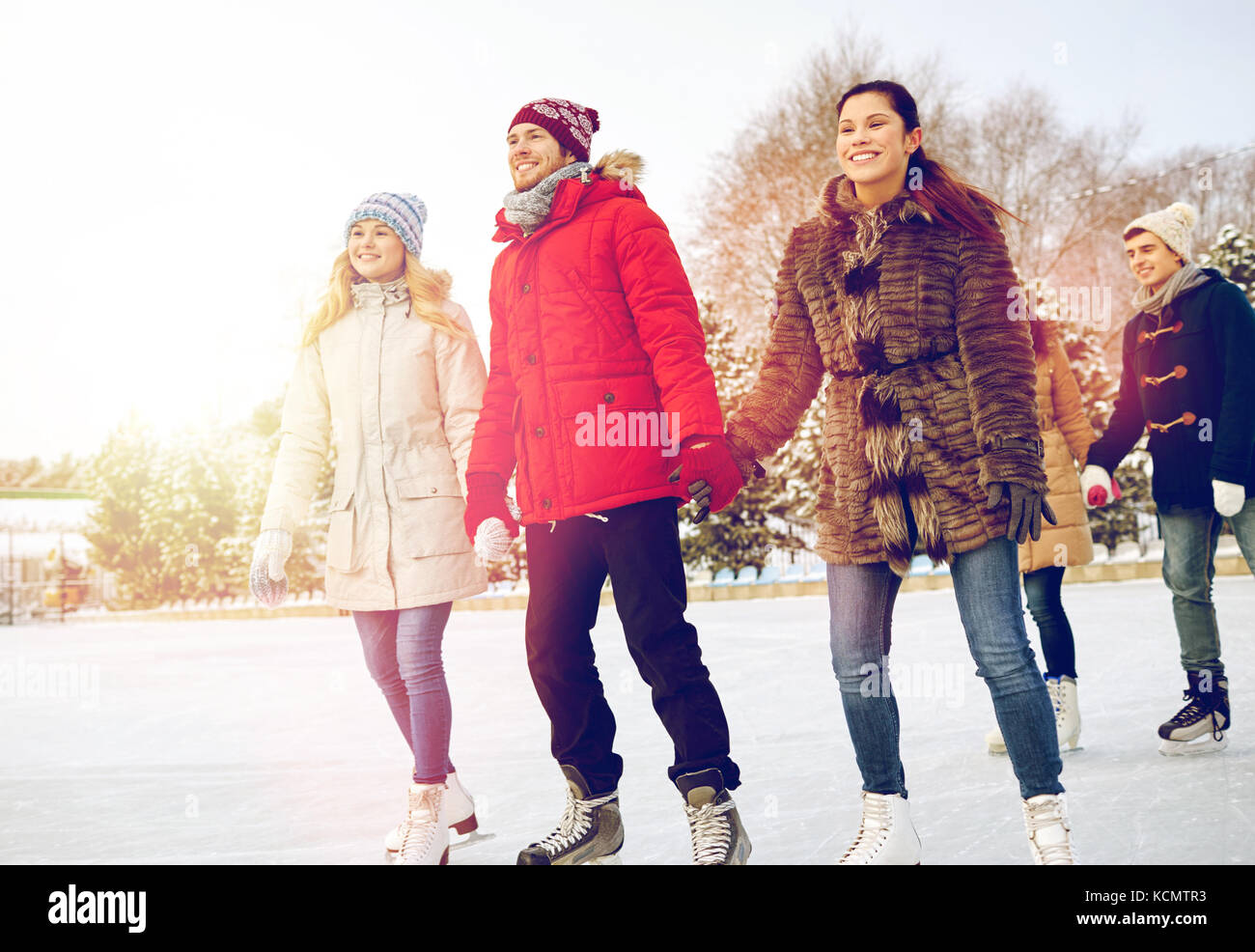 happy friends ice skating on rink outdoors Stock Photo - Alamy