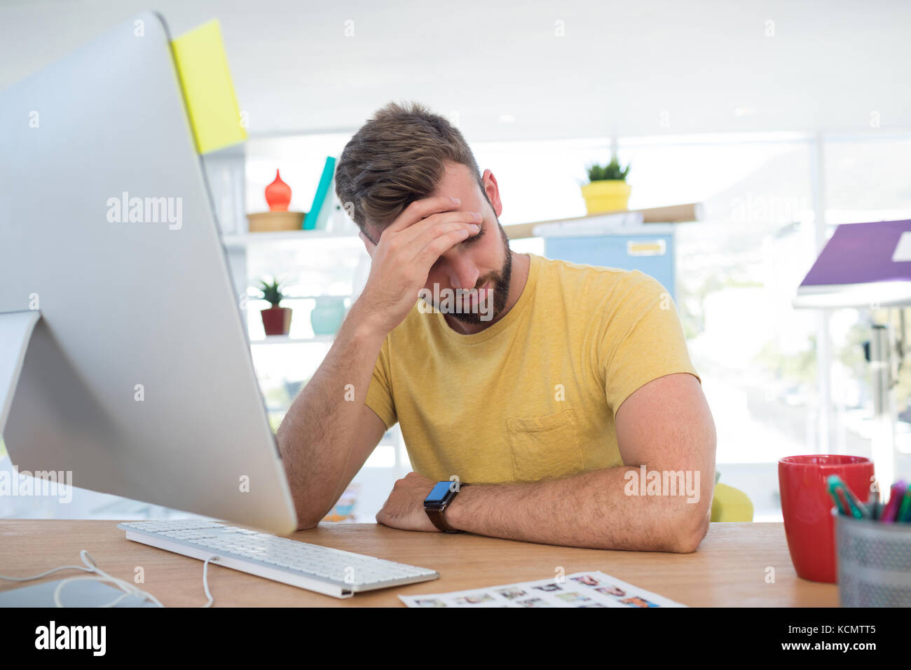 Depressed male executive working on computer in the office Stock Photo ...