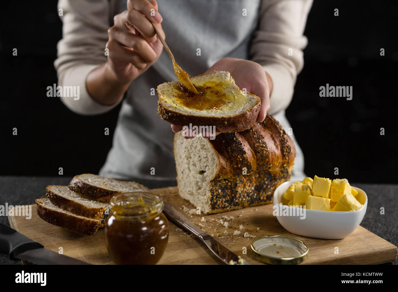 Close-up of woman applying jam over multigrain bread slice Stock Photo ...
