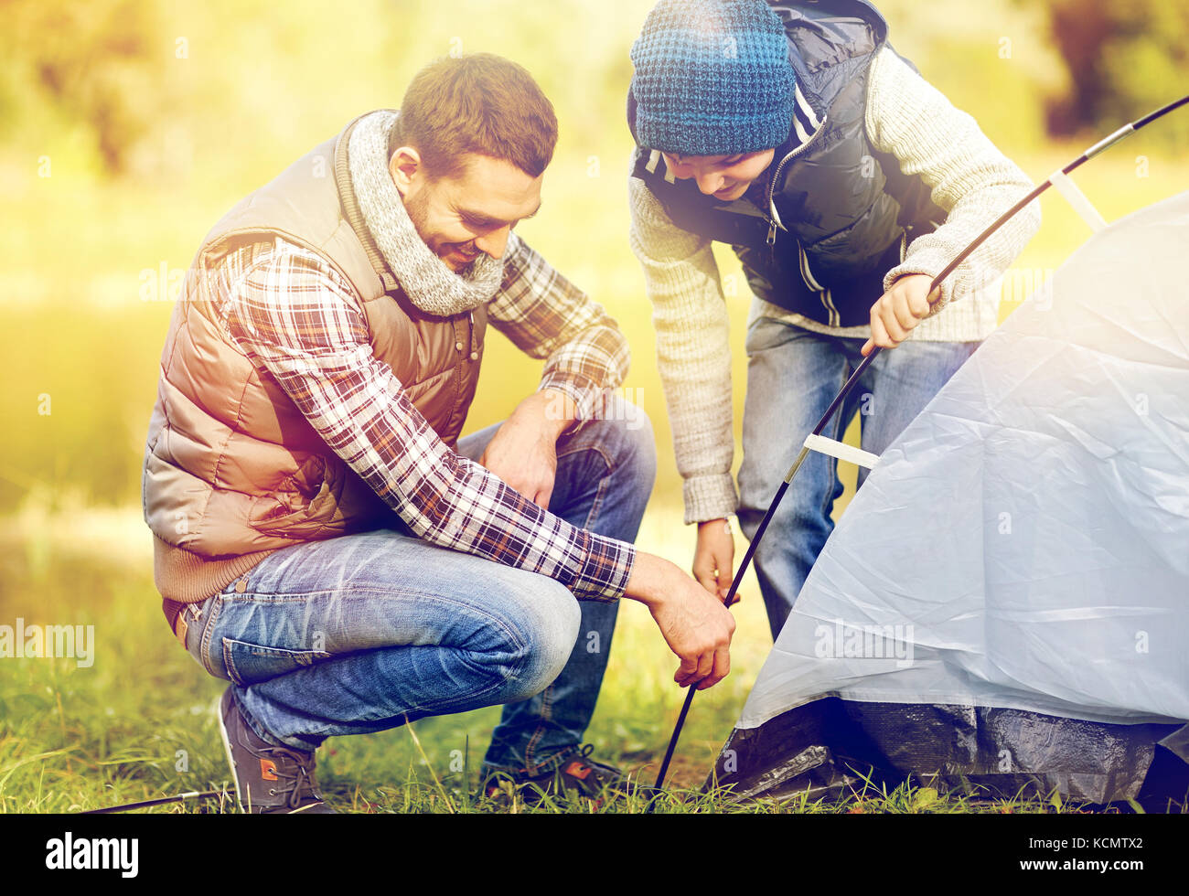 happy father and son setting up tent outdoors Stock Photo - Alamy