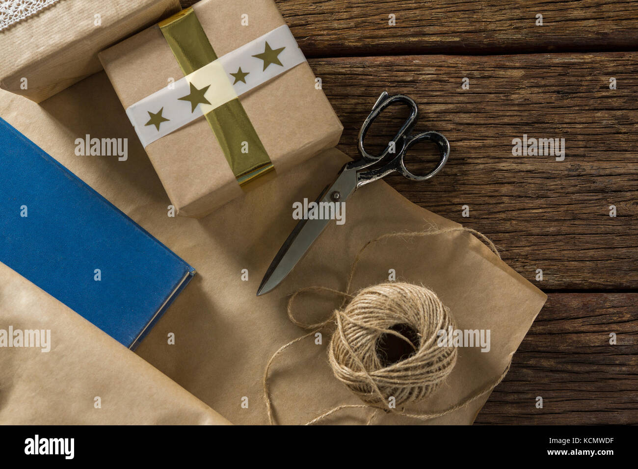 Paper with gift box by scissor and thread spool on table Stock Photo ...