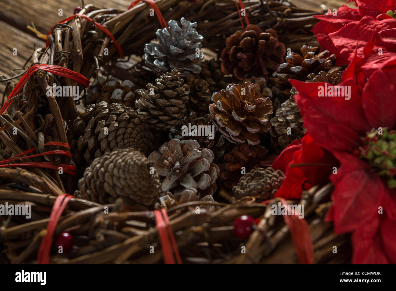 Close up of artificial nest with pine cones and poinsettia flowers on ...