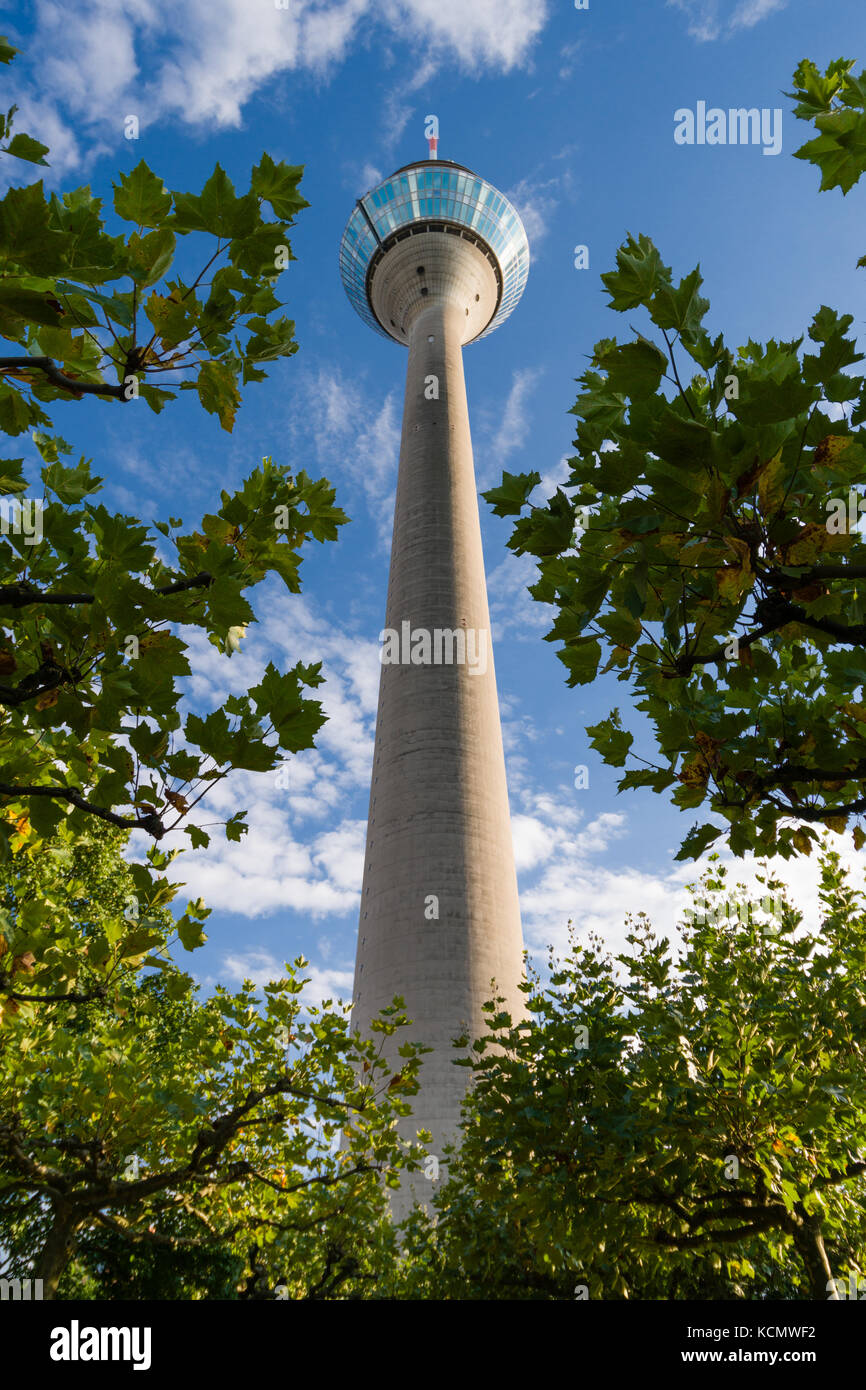 Low-angle view of the Rhine Tower in Dusseldorf against a cloudy blue ...