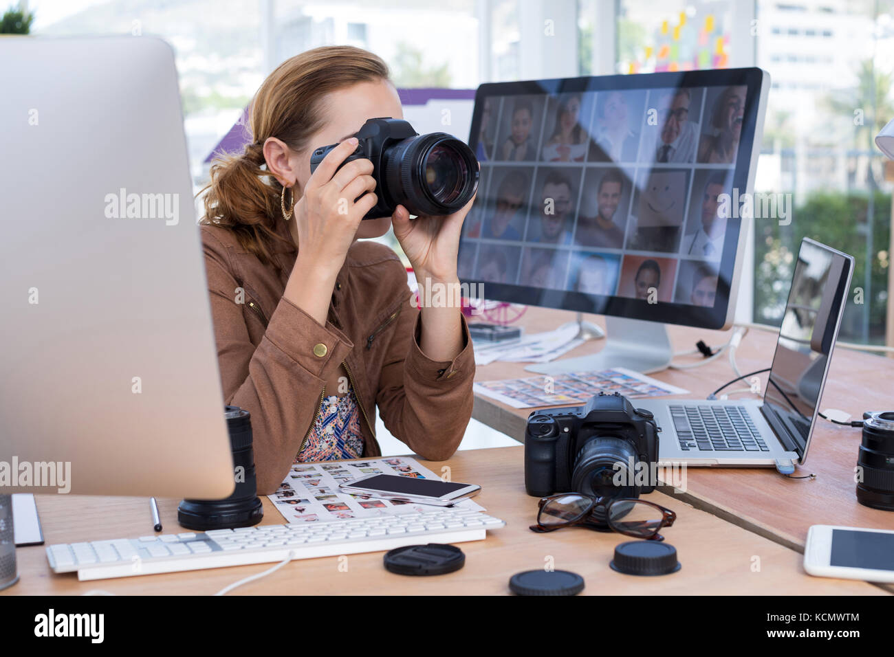 Female executive taking a photograph from digital camera in office ...