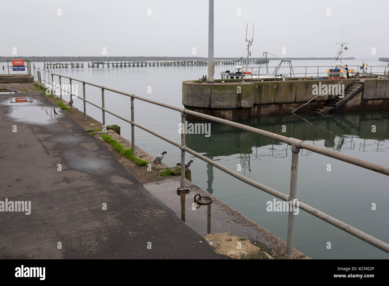 A landscape of dock railings and harbour walls and a seascape of a ...