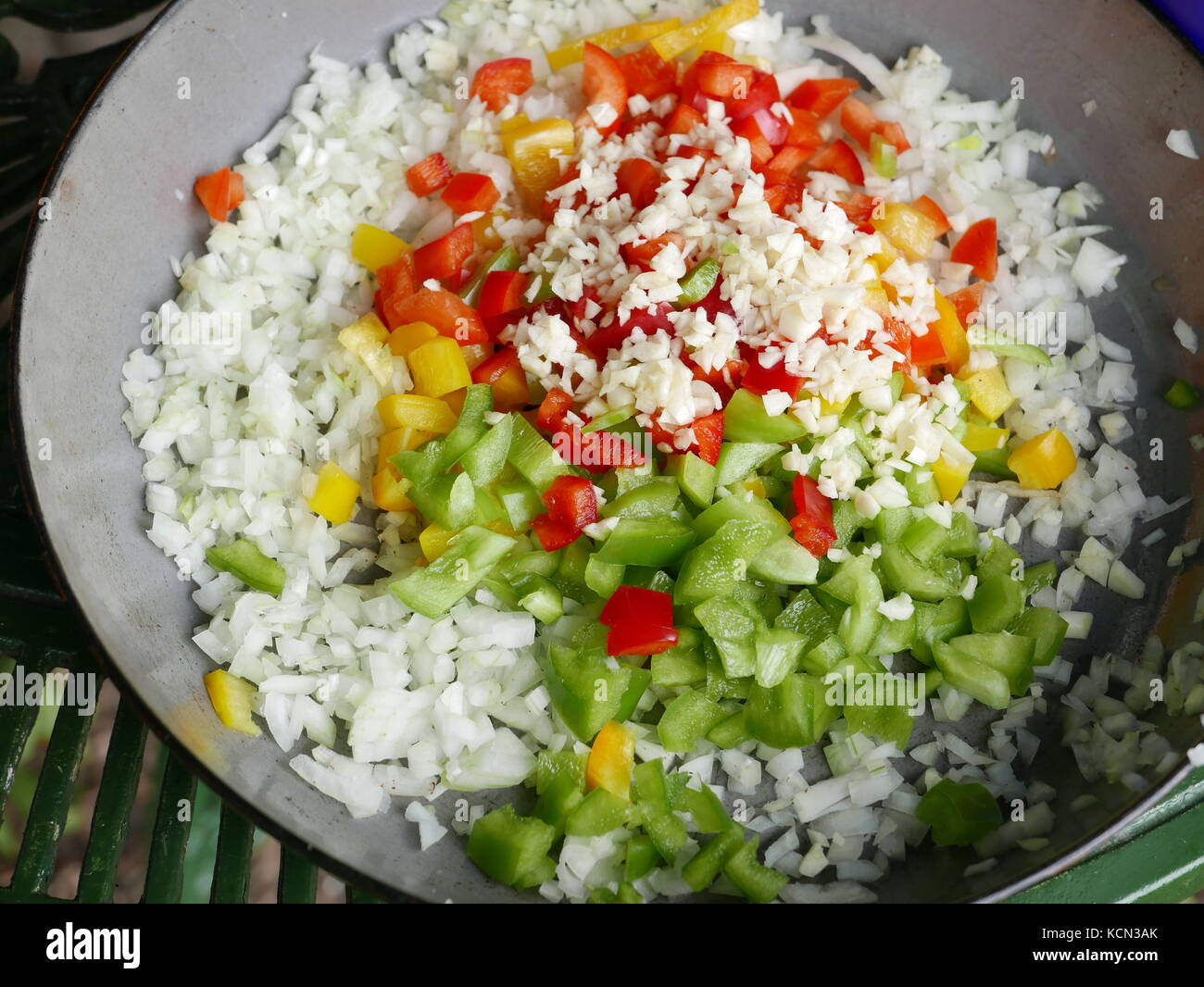 Onion, red, green and yellow pepper frying in a pan Stock Photo - Alamy