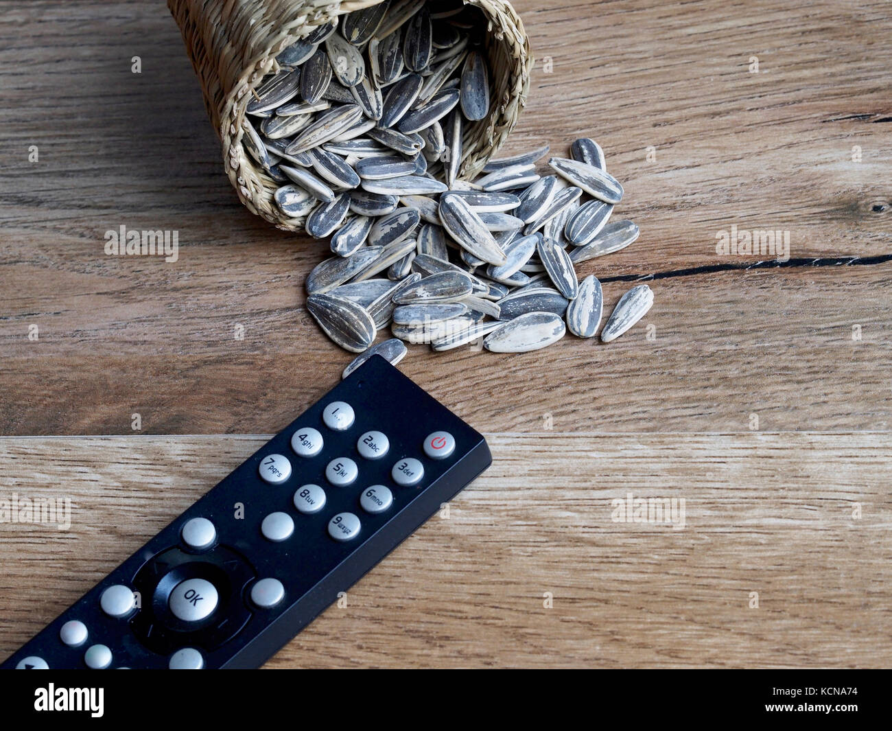 Sunflower seeds in wicker basket and remote control tv Stock Photo - Alamy
