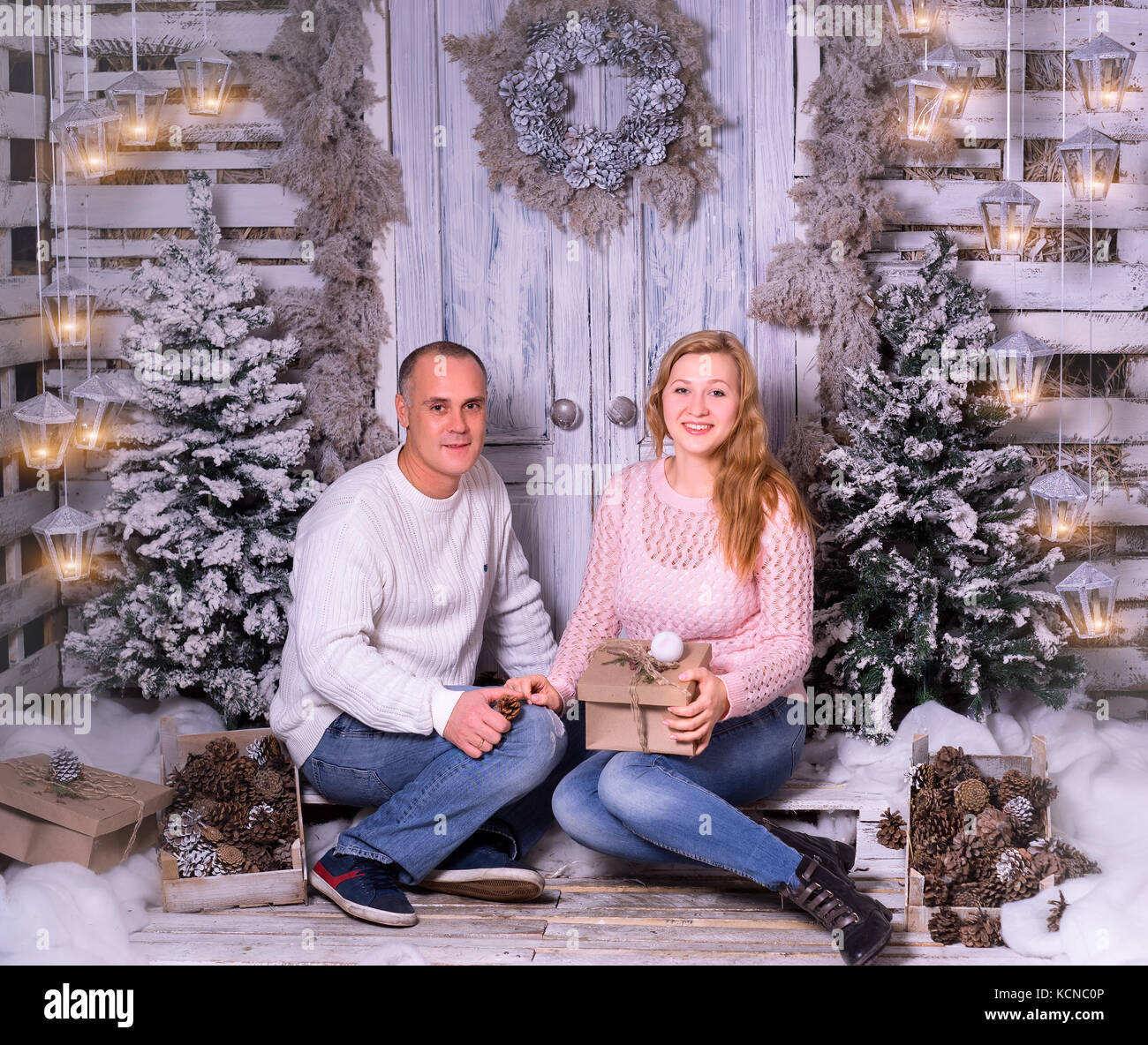 Studio shot of two happy people at doorstep during winter holidays ...