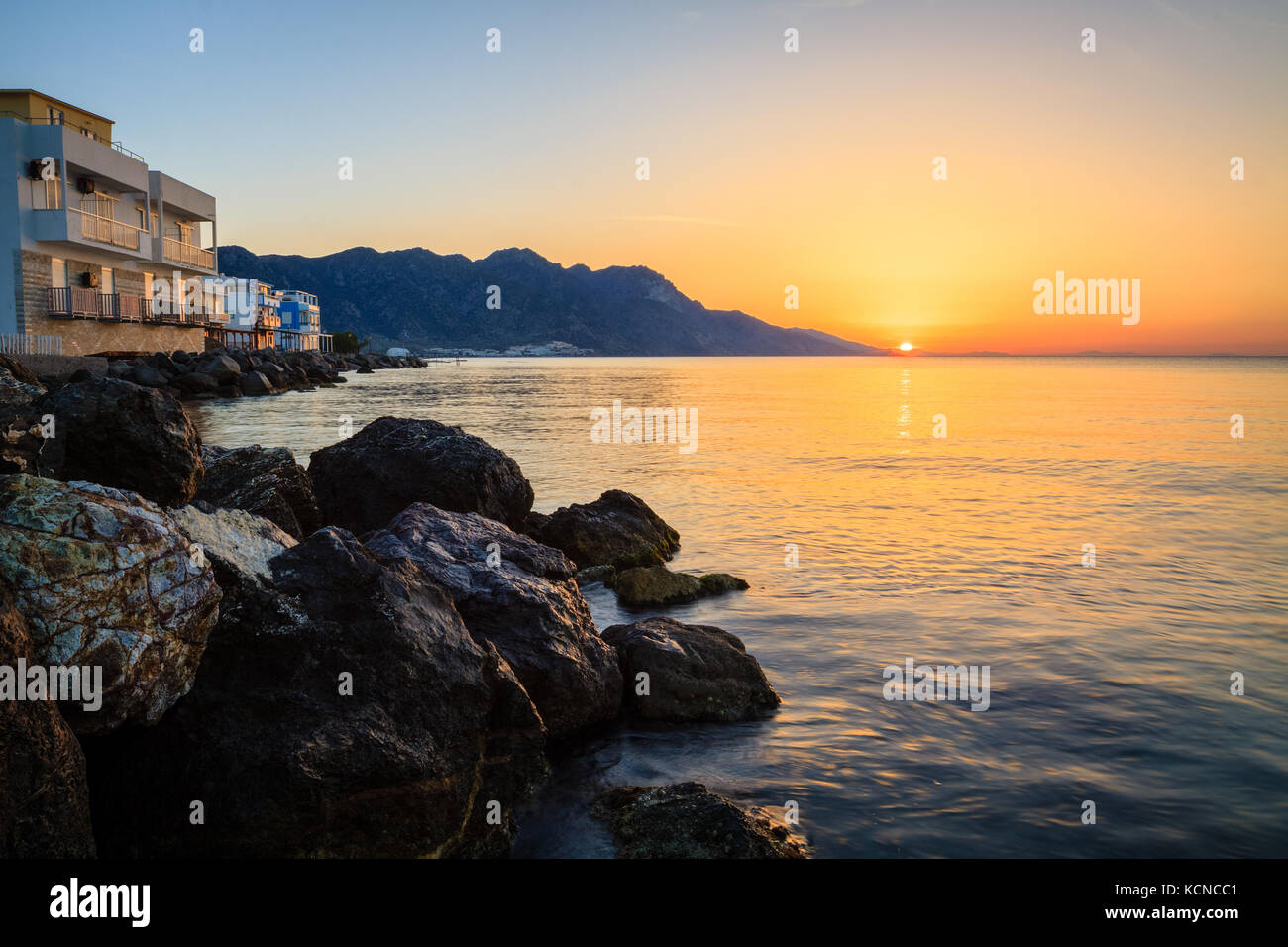 Beautiful sunrise landscape with sea, rock and mountains Stock Photo ...